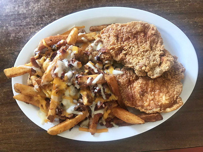 Loaded fries and golden pork chops sharing a plate like old friends. The kind of meal that requires both a fork and a nap afterward.