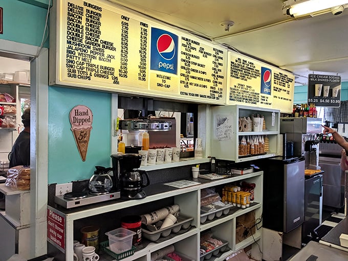 Behind the counter, where burger magic happens. No fancy equipment, just well-seasoned surfaces that have been turning out perfection for generations.