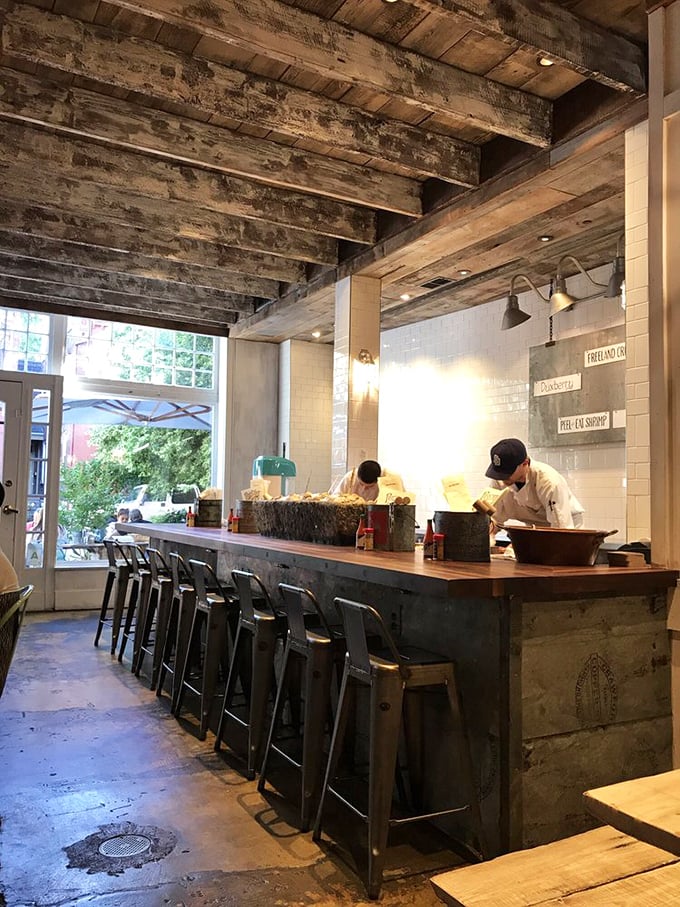 Behind this rustic bar, seafood magic happens – where oysters are shucked with the precision of a Swiss watchmaker.
