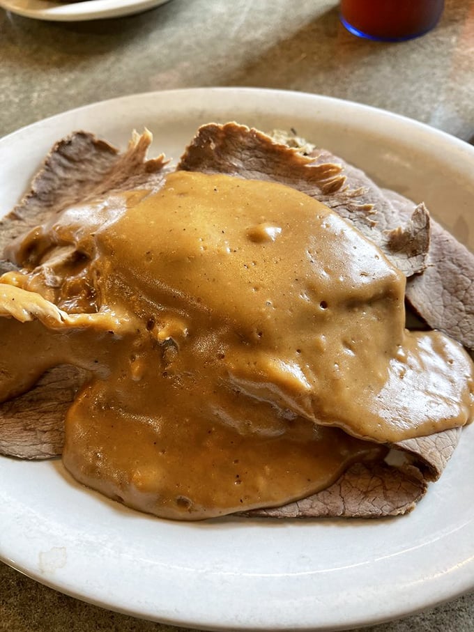 Roast beef draped in gravy like it's wearing a luxurious velvet robe. This isn't just lunch – it's a coronation ceremony for your taste buds.