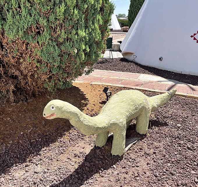 A friendly concrete dinosaur guards the grounds because apparently every roadside attraction needs a mascot.