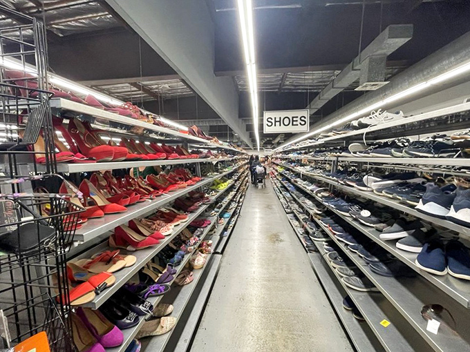 The shoe aisle stretches into infinity—a Carrie Bradshaw fantasy at fraction-of-retail prices. Red pumps to the left, sensible sneakers to the right.