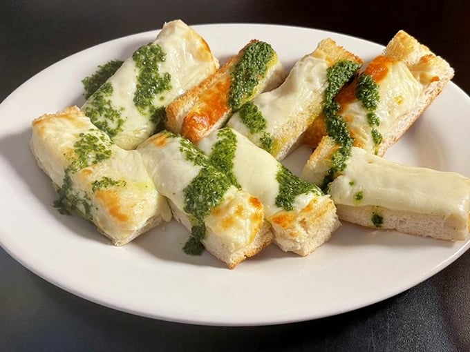Cheese toast reimagined as a work of art. The pesto drizzle isn't just garnish—it's the signature on a masterpiece of melty perfection.