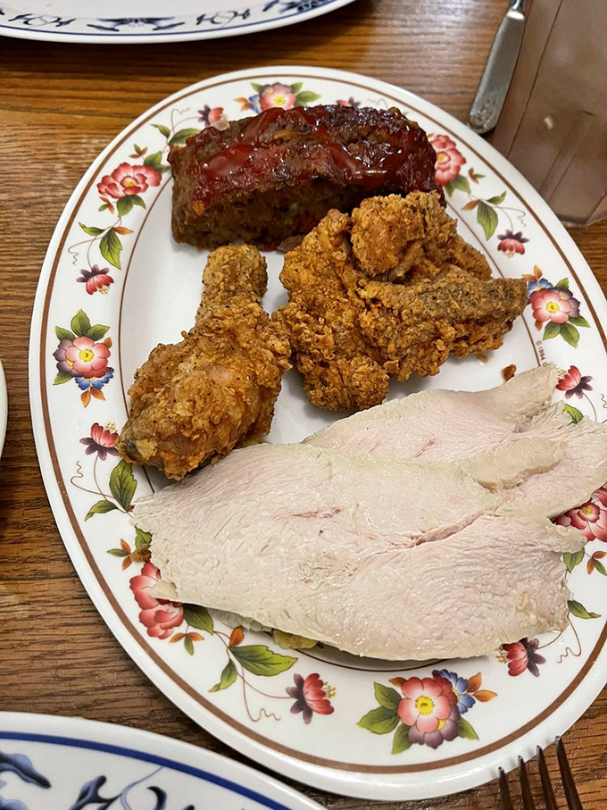 The holy trinity of Southern comfort: meatloaf with sweet glaze, golden fried chicken, and sliced turkey—a plate that says "nap time follows immediately."