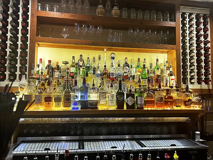 A bar stocked like an Italian wedding reception. The illuminated bottles promise liquid courage before you attempt to pronounce "bruschetta" correctly.