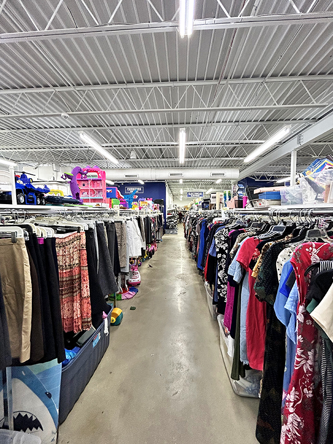 The clothing aisles stretch like a textile Grand Canyon. Each hanger holds potential—someone's "too small" might be your "fits just right."