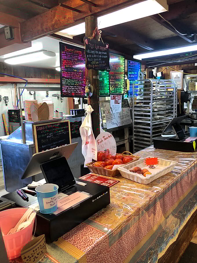 Behind this counter, magic happens daily. Fresh tomatoes waiting their turn while colorful menu boards announce the day's treasures.