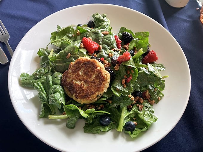 This crab cake isn't playing supporting actor to those berries and greens – it's the undisputed star with a well-deserved spotlight.