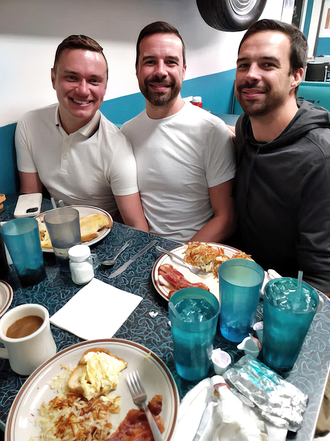 Happy faces around the table tell the real story—good food creates good memories, especially when blue glasses are involved.
