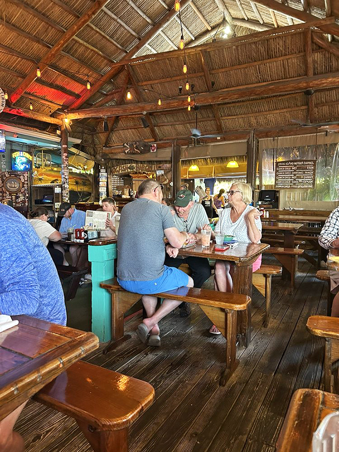 Under that soaring thatched ceiling, strangers become friends and friends become family. The picnic tables aren't just furniture—they're community builders.