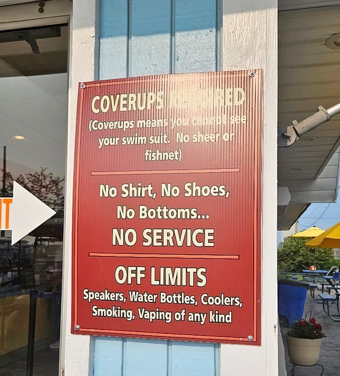 Rules with personality—the sign's humor softening its strict message about proper attire, proving even paradise needs some boundaries.