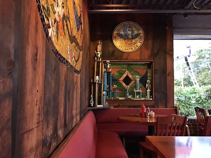 Red booth seating and wooden walls create that perfect diner-meets-cabin vibe. Those trophies? Evidence that breakfast can be competitive sport.