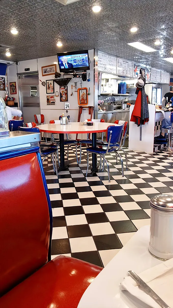 Red booths, blue chairs, and a checkerboard floor—dining in what feels like a delicious game of American diner chess.