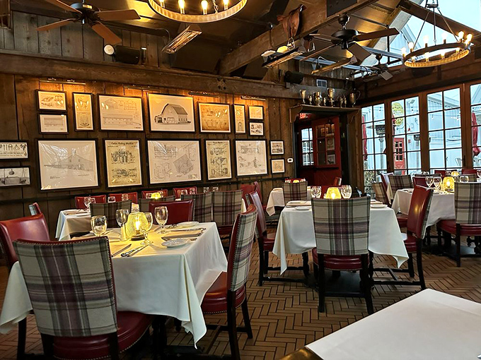 White tablecloths meet rustic wood walls in a dining room where plaid chairs and vintage prints create the perfect backdrop for serious eating.