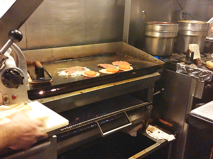 Behind the scenes, skilled hands work the grill where cheesesteak magic happens one perfectly cooked order at a time.