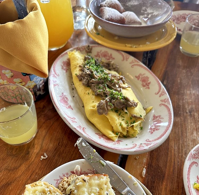 This isn't just an omelet; it's a golden envelope delivering a love letter of flavors. The herbs sprinkled on top are like delicious confetti.