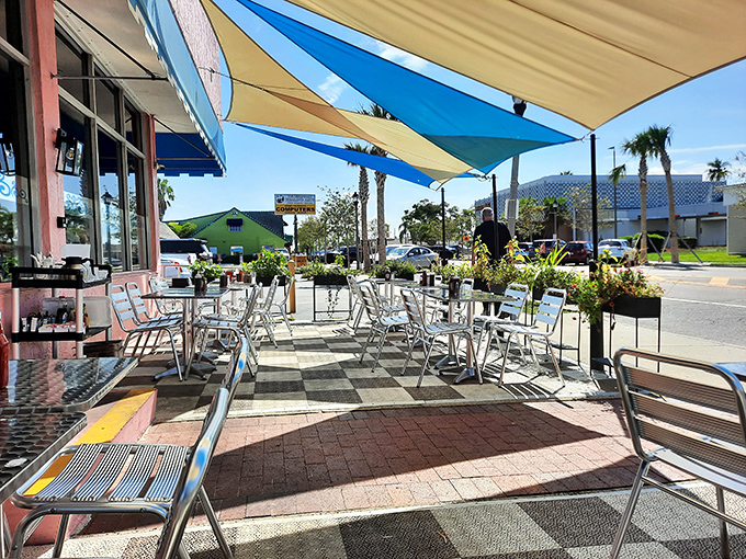 The outdoor seating area—where breakfast meets vitamin D. Those sail shades aren't just decorative; they're saving your mimosa from turning into orange juice soup.