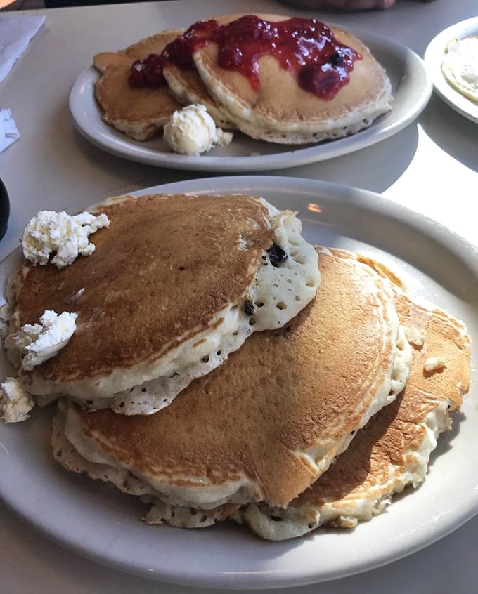Pancakes stacked higher than my weekend ambitions. The berry topping isn't just delicious—it's technically a serving of fruit, which makes this health food, right?