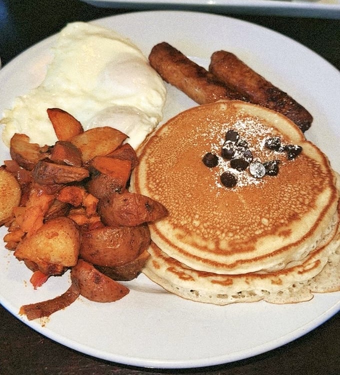 Pancakes stacked high, dotted with blueberries and accompanied by potatoes and sausage—the breakfast trifecta that makes mornings worth facing.