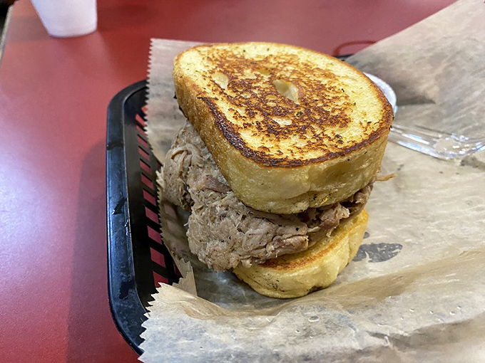 This pulled pork sandwich between buttered toast represents everything right about American comfort food done properly.