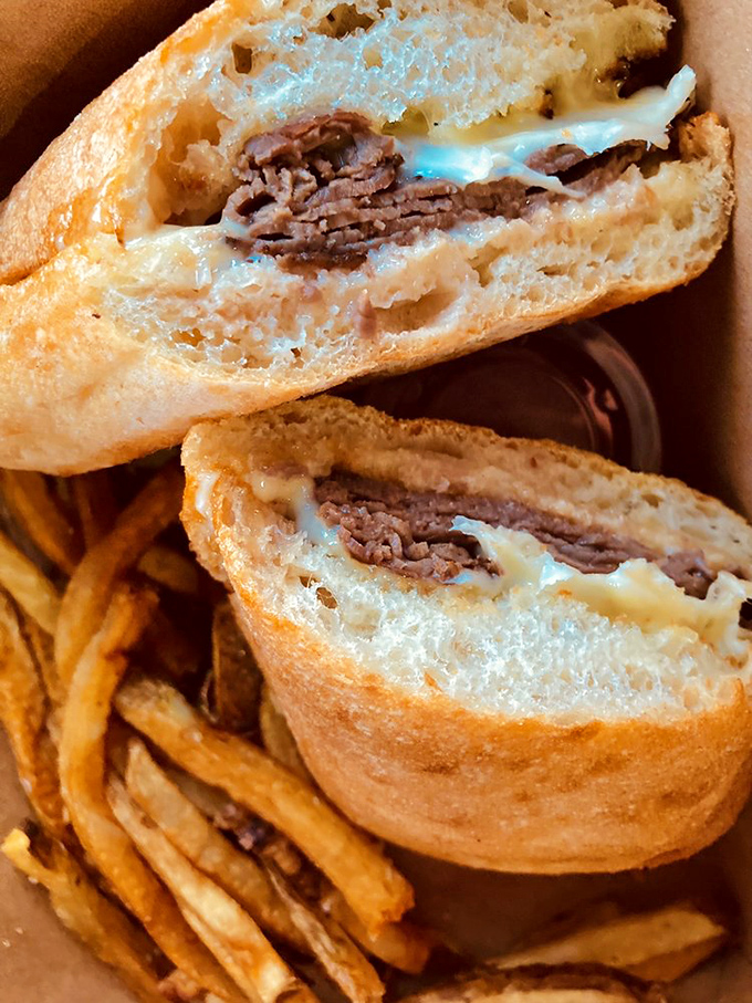 The cross-section of this roast beef sandwich reveals the architectural genius behind it—tender meat, melted cheese, and bread that knows its purpose.