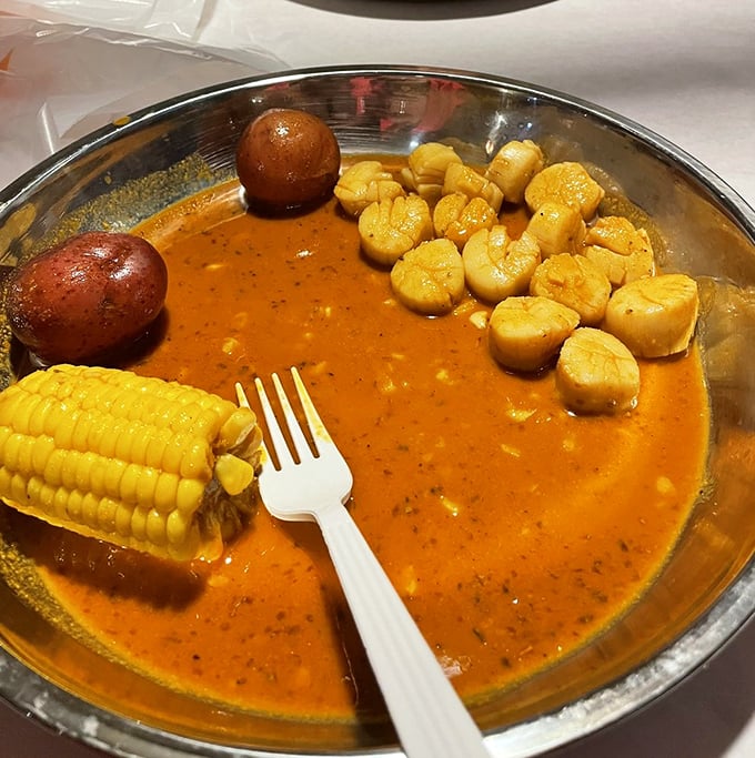 Scallops bathing in spiced sauce with corn and potatoes—a seafood hot tub party where everyone's invited to dive in.