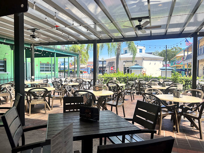 The covered patio seating area offers Florida dining without Florida sweating—palm trees included at no extra charge.