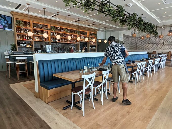 The bar area isn't just well-stocked—it's a shrine to libations with warm wood shelving, globe lighting, and enough spirits to make any cocktail enthusiast weak in the knees.
