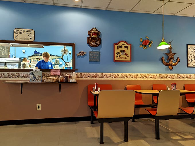 The service window offers a glimpse into the kitchen operations. Nautical decorations reinforce the maritime theme throughout the restaurant.