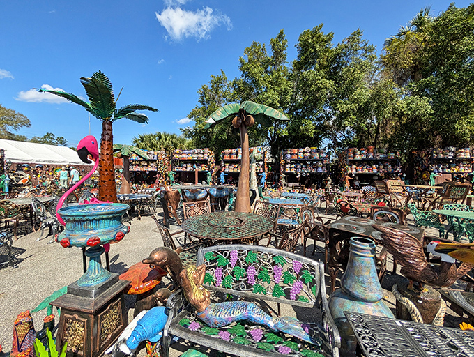 Metal palm trees create permanent shade over mosaic tables, offering a glimpse of paradise that never needs watering or trimming.