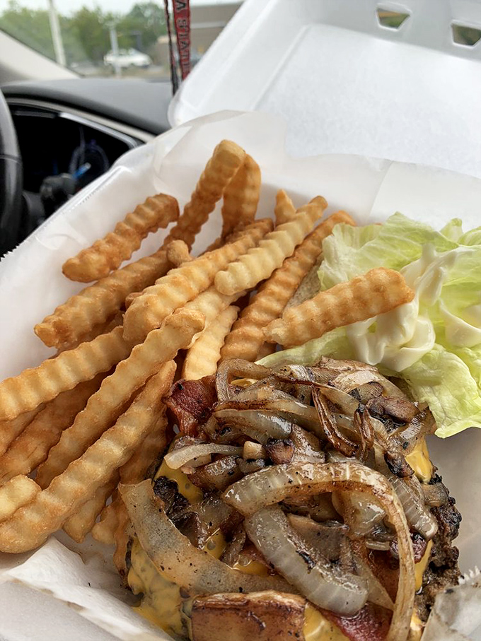 This bacon cheeseburger with grilled onions isn't just lunch—it's therapy on a bun. The fries standing at attention know they're in the presence of greatness.
