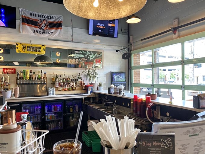 The bar area showcases local pride with Ohio flags and brewery banners – because good BBQ deserves equally thoughtful beverage companions.