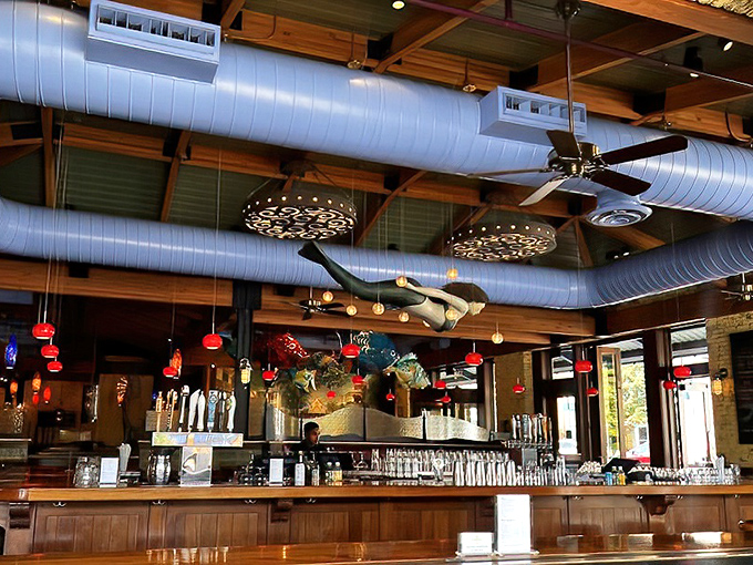 The bar where maritime meets mixology – those hanging fish sculptures seem to approve of your cocktail choice.