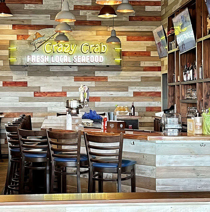 The bar's reclaimed wood panels tell stories of coastal charm, while the neon sign reminds you exactly why you're here—for crazy good crab.