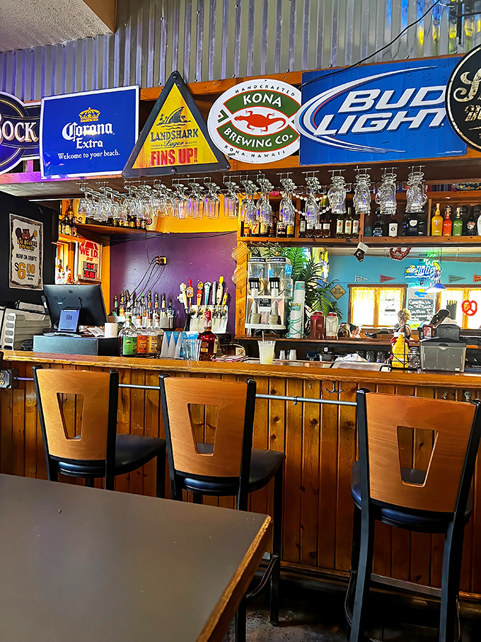The bar area strikes that perfect balance between dive bar authenticity and vacation vibes—where beer signs glow like beacons and glasses hang ready for the next pour.