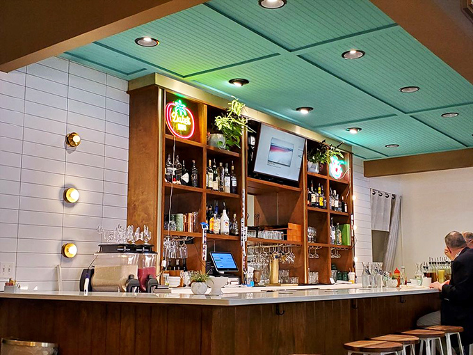The bar area glows with possibility under that mint-colored ceiling—breakfast by day, cocktails when the mood strikes.