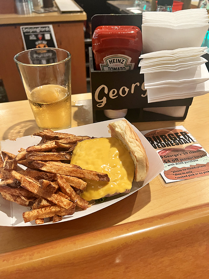 The holy trinity of comfort food: cold beer, hot burger, and hand-cut fries that make frozen potatoes weep with inadequacy.