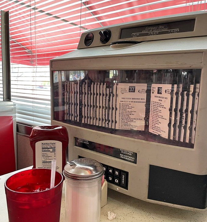 The tabletop jukebox whispers of simpler times, when dropping a quarter for your favorite tune was the height of dinner entertainment.