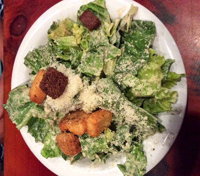 A Caesar salad that actually deserves respect—crisp romaine embraced by creamy dressing and crowned with crunchy croutons that weren't born in a box.