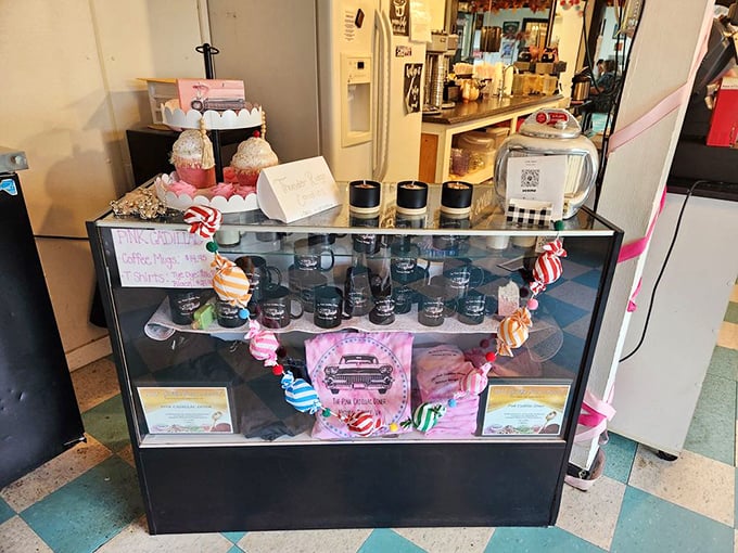 The gift shop display case offers pink-themed souvenirs—because the only thing better than eating here is taking a piece of it home.