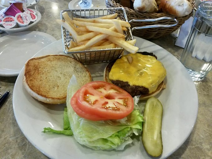 A cheeseburger that doesn't need Instagram filters – just napkins. The pickle standing guard ensures no bite is without that perfect tang.