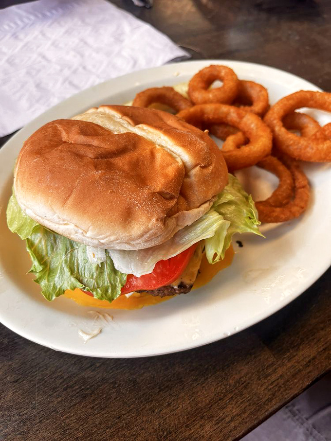 A classic American cheeseburger with onion rings—proof that simplicity, when done with conviction, beats complexity every time.