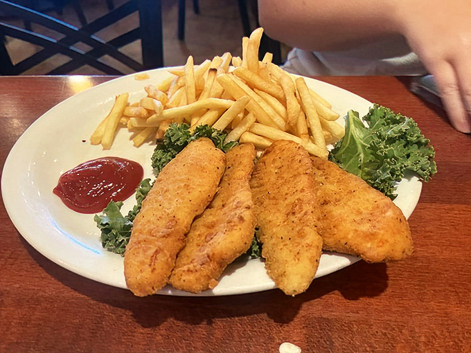 Golden-fried chicken tenders that achieve that perfect balance—crispy exterior giving way to juicy interior—with fries that could steal the show on their own.
