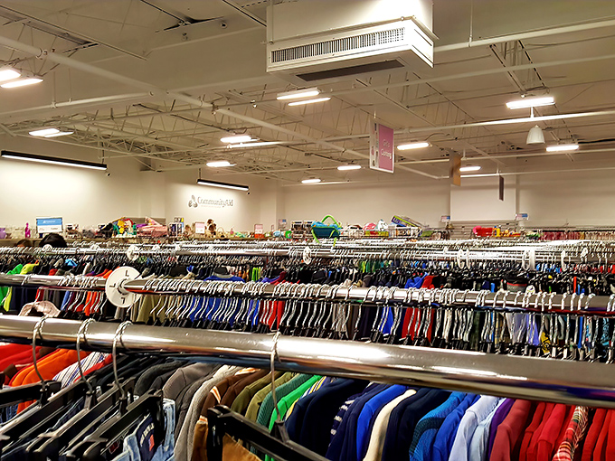 The rainbow of hanging garments stretches toward the horizon—a textile landscape where fashion finds hide in plain sight.