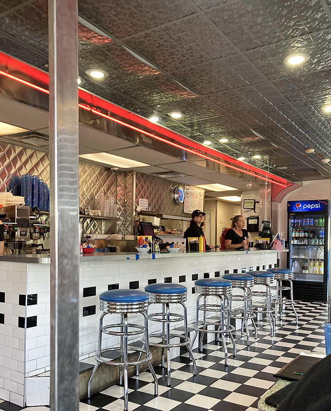 The counter where magic happens—complete with blue spinning stools that practically beg you to swivel while waiting for your order.