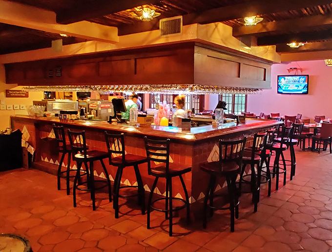 The bar area beckons with promises of margaritas and memories – the perfect perch for people-watching while awaiting your table.