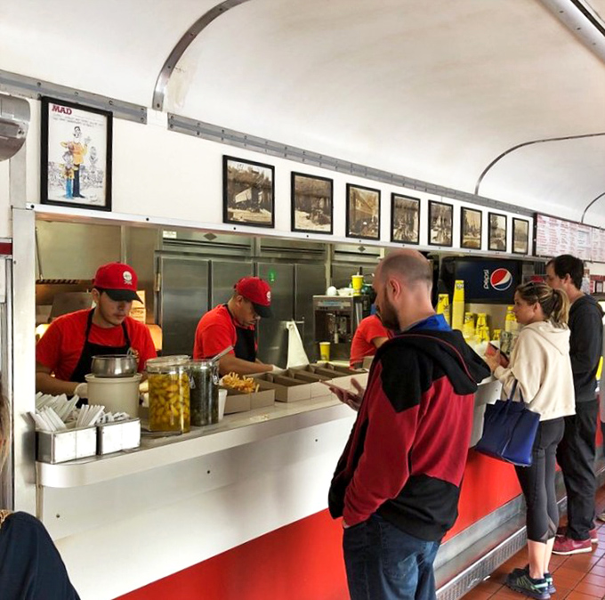 At the counter, where culinary magic happens, staff in bright red shirts prepare orders with the efficiency of a well-oiled locomotive.