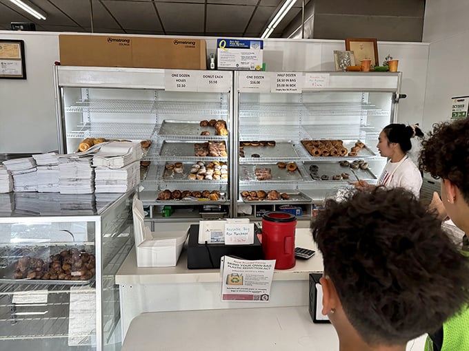 Nearly empty shelves tell the real story—these donuts don't stick around long. The early bird gets the fritter; the late bird gets lessons in punctuality.