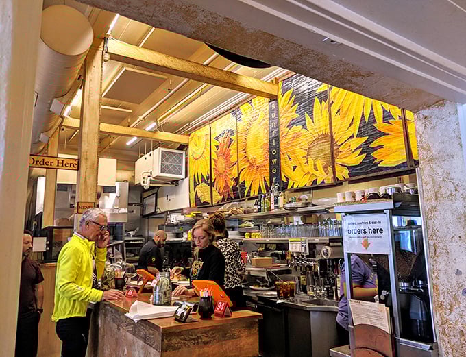 Where the magic happens. That sunflower mural isn't just decoration—it's a preview of the sunny flavors coming from behind the counter.