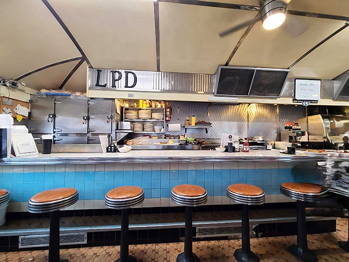 The counter seats—front-row tickets to the best show in town, where breakfast theater unfolds with the precision of a well-rehearsed Broadway production.
